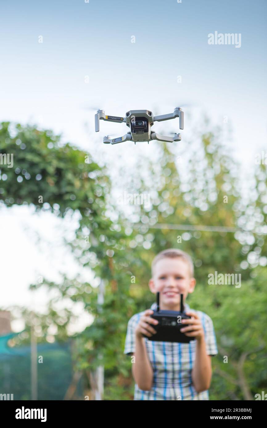 Kid flying drone. Boy operate drones. Child Operating Quadcopter ...