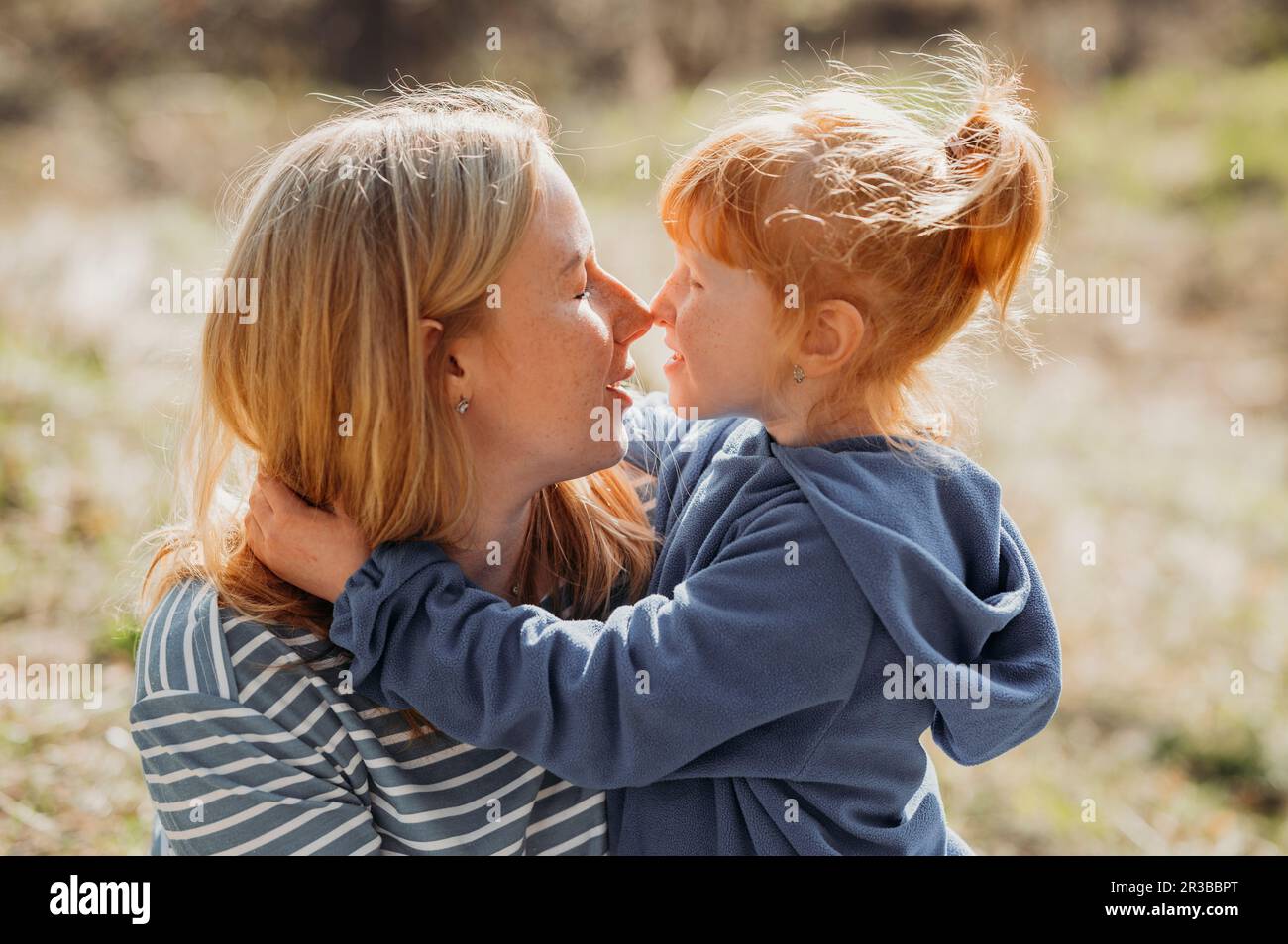 Mother and daughter rubbing noses on sunny day Stock Photo - Alamy