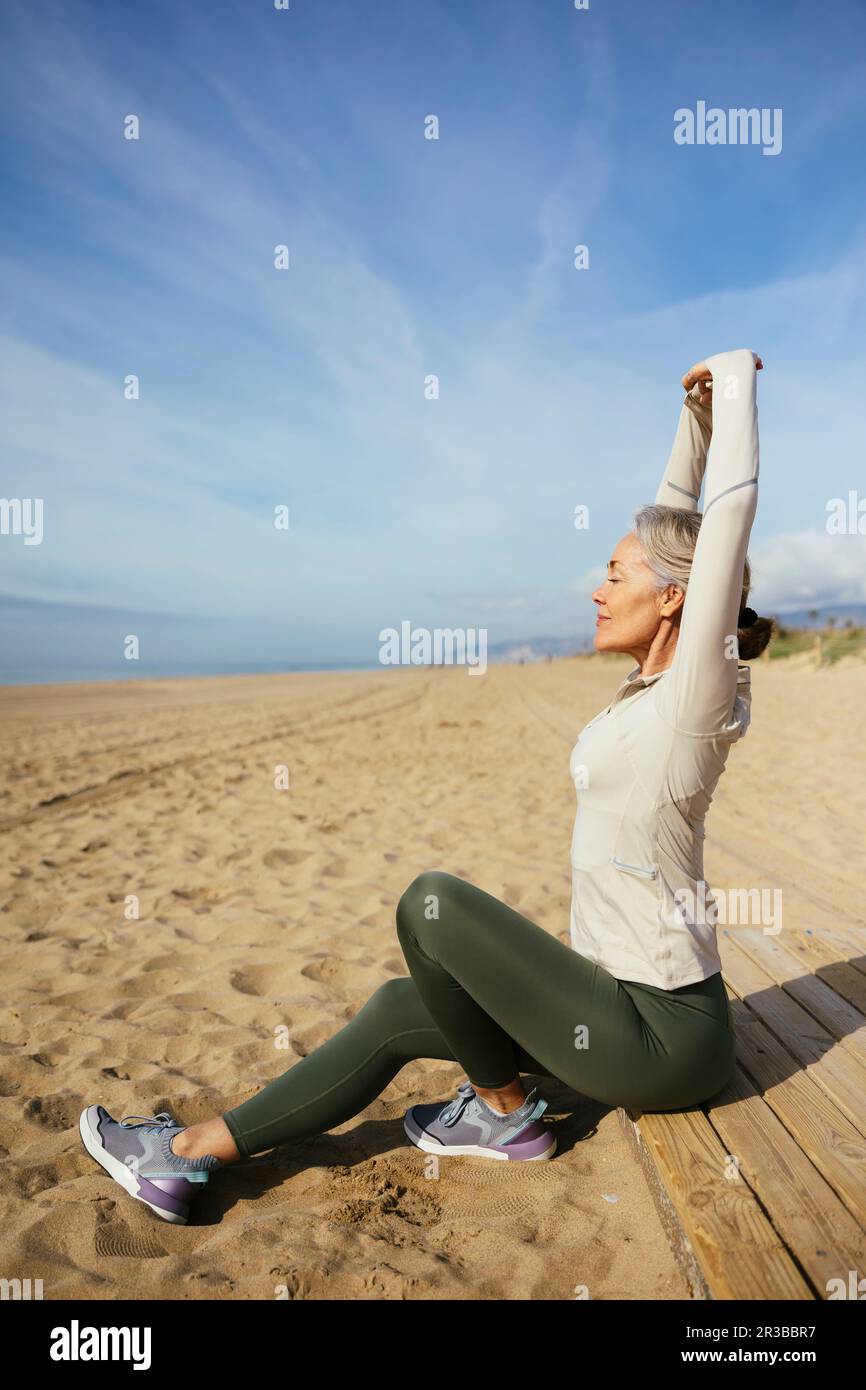 Woman sitting on beach stretching hi-res stock photography and images ...
