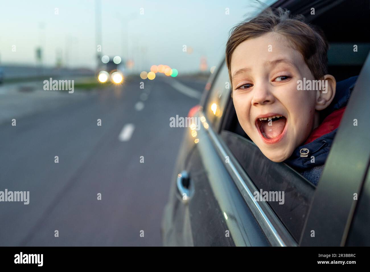 Carefree boy screaming out of car window Stock Photo - Alamy