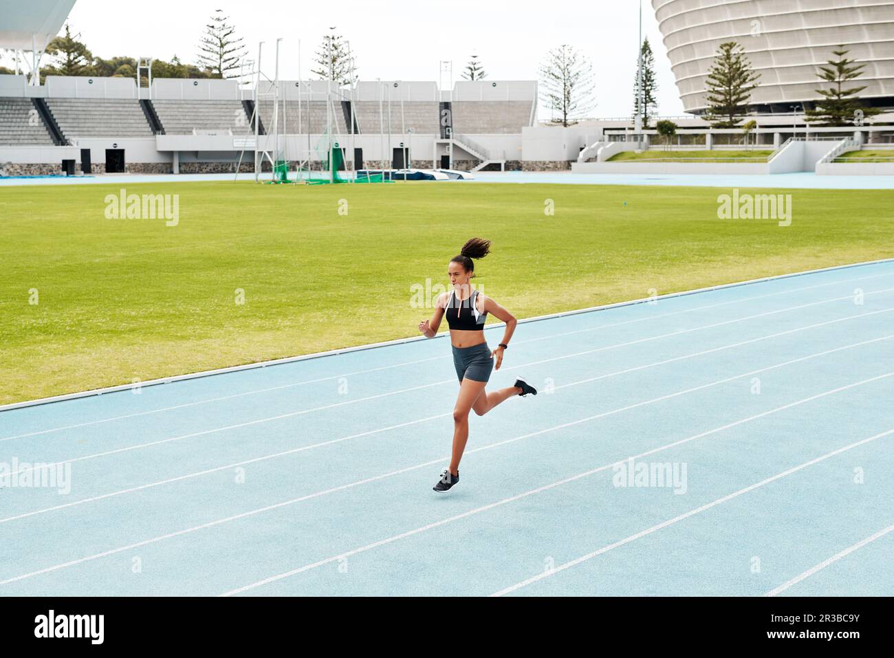 Woman, fitness and running on stadium track for exercise, cardio ...