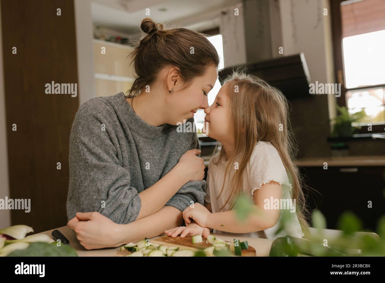 Mother and daughter rubbing noses in kitchen Stock Photo - Alamy