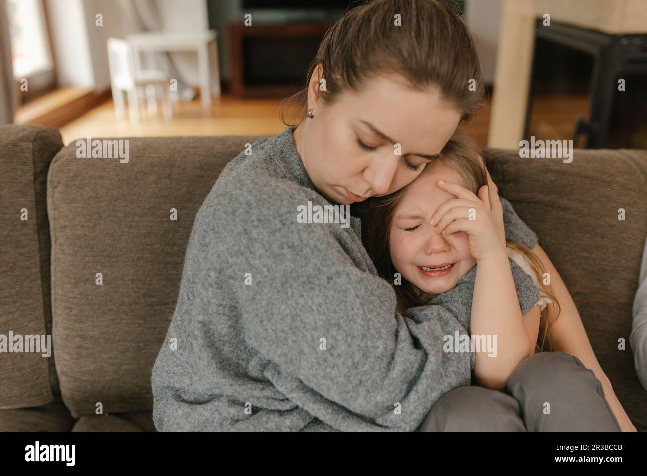 Mother consoling crying daughter on sofa Stock Photo - Alamy