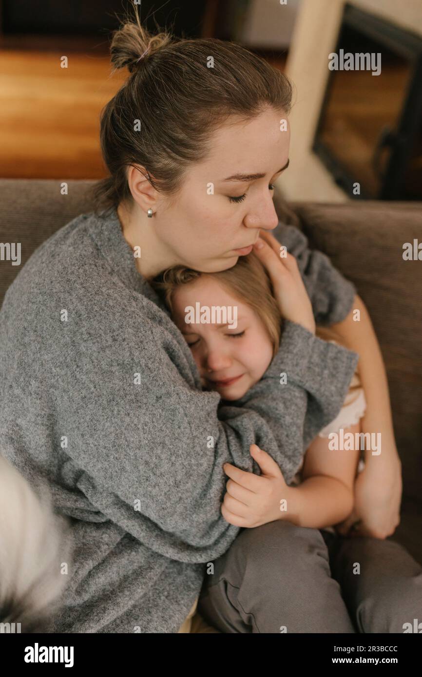 Mother consoling crying daughter at home Stock Photo - Alamy
