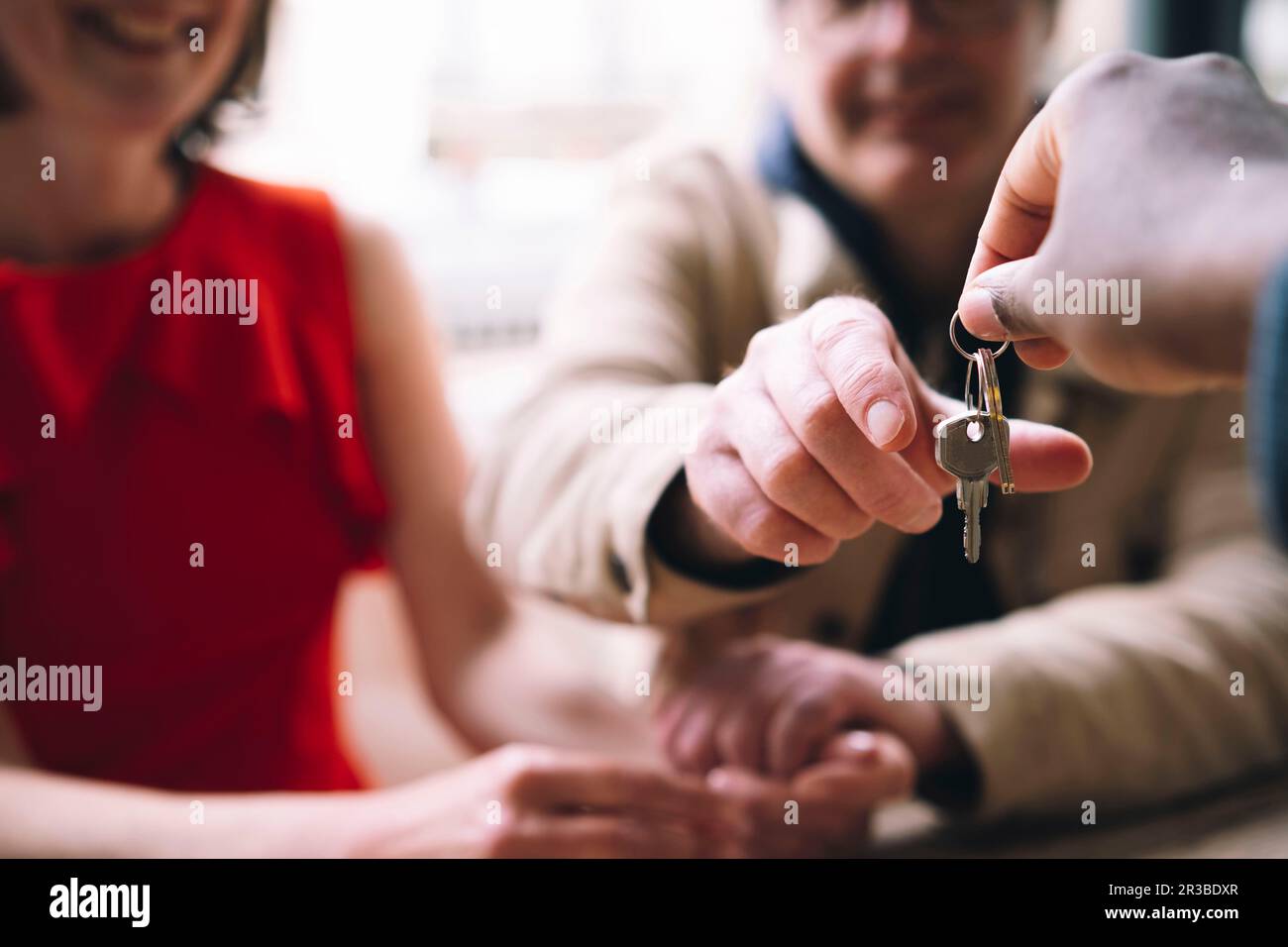 Real estate agent giving house keys to couple Stock Photo - Alamy