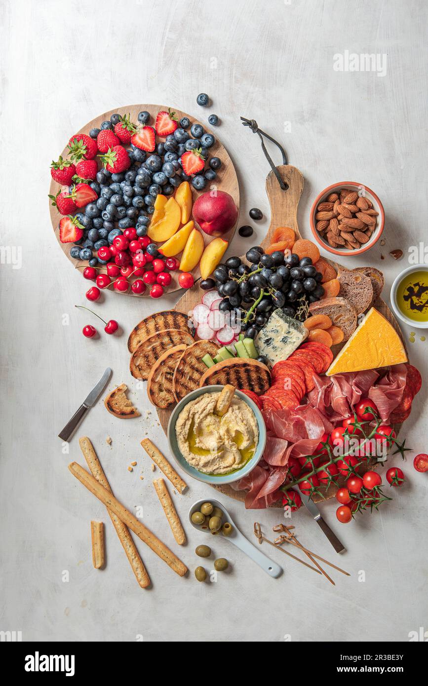 Deli platter with ham, cheese, hummus, olives, fresh fruit and bread ...