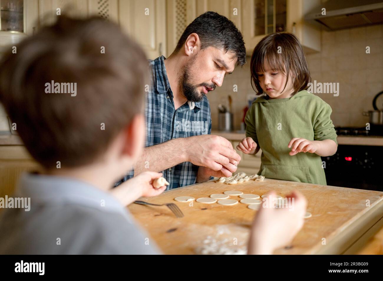 Father teaching children to make dumplings at kitchen Stock Photo - Alamy