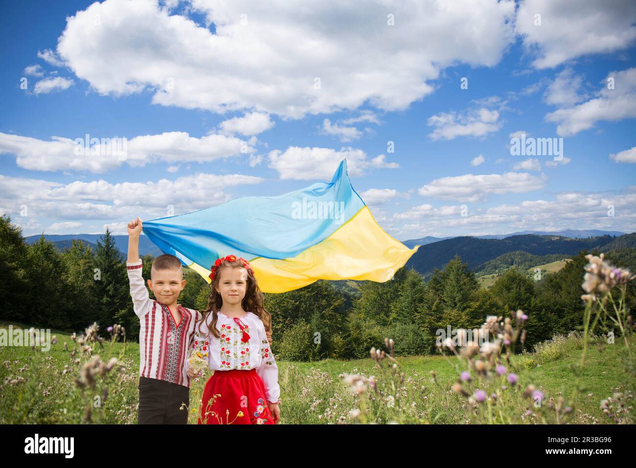 Little Ukrainian girl and boy holding a blue and yellow Ukrainian flag ...