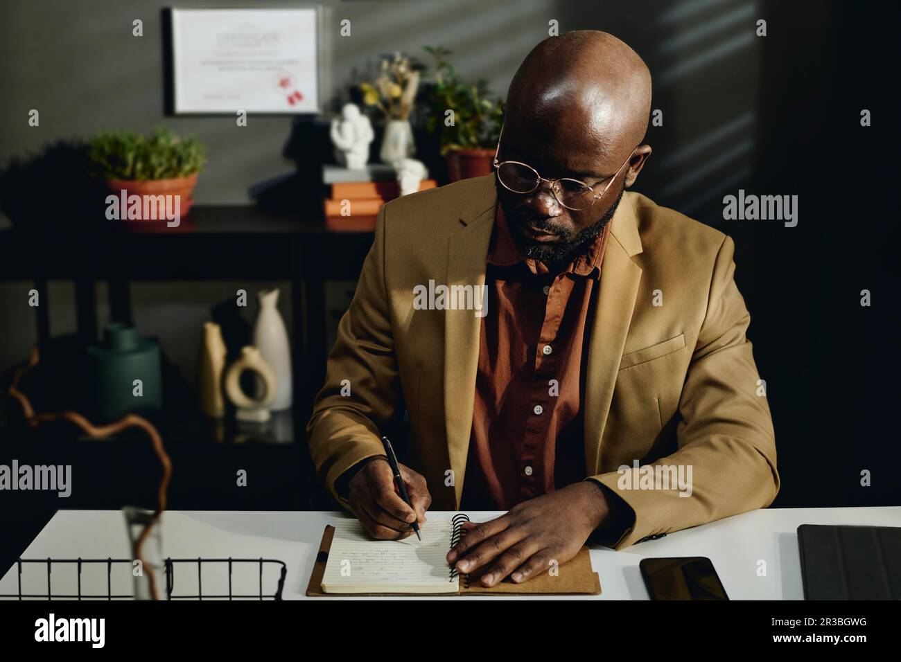 Psychologist sitting desk writing in hi-res stock photography and ...