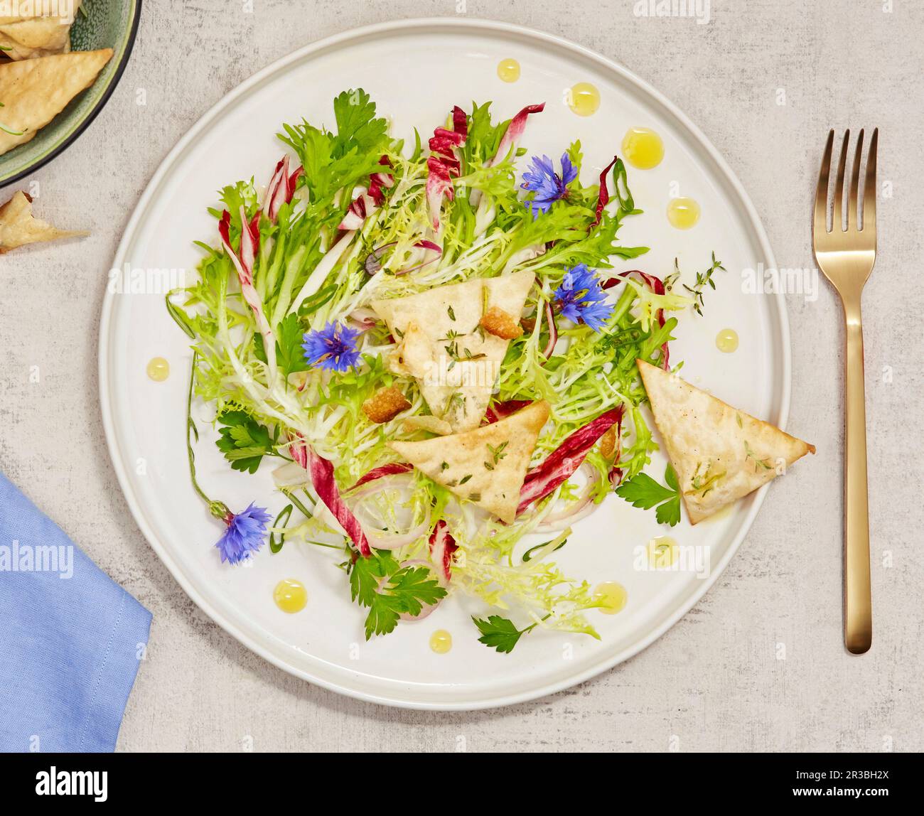 Frisée salad with wild flowers, rocket and rosemary chips Stock Photo ...