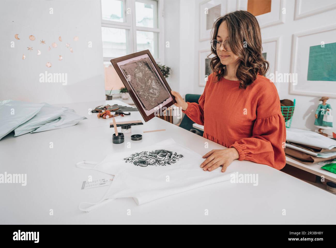 Fashion designer printing design on dress at workshop Stock Photo - Alamy