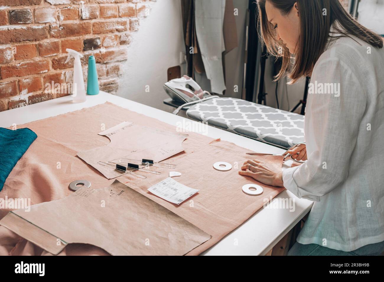 Fashion designer cutting fabric at workshop Stock Photo - Alamy