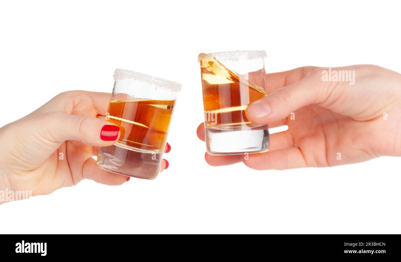 Two hands clinking shots of alcoholic beverage together Stock Photo - Alamy