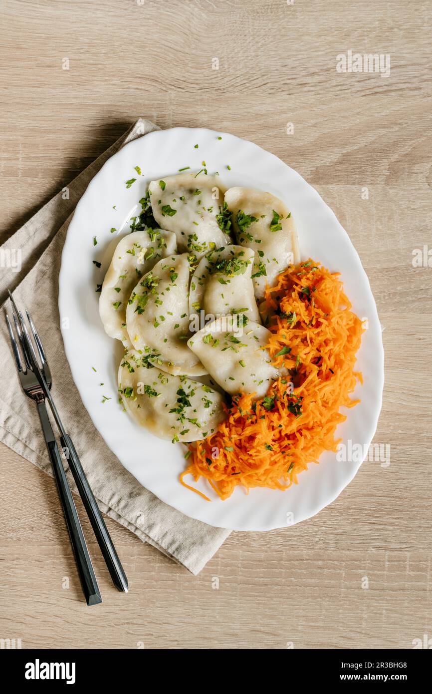 Polish meat pierogi with carrot garnish Stock Photo - Alamy