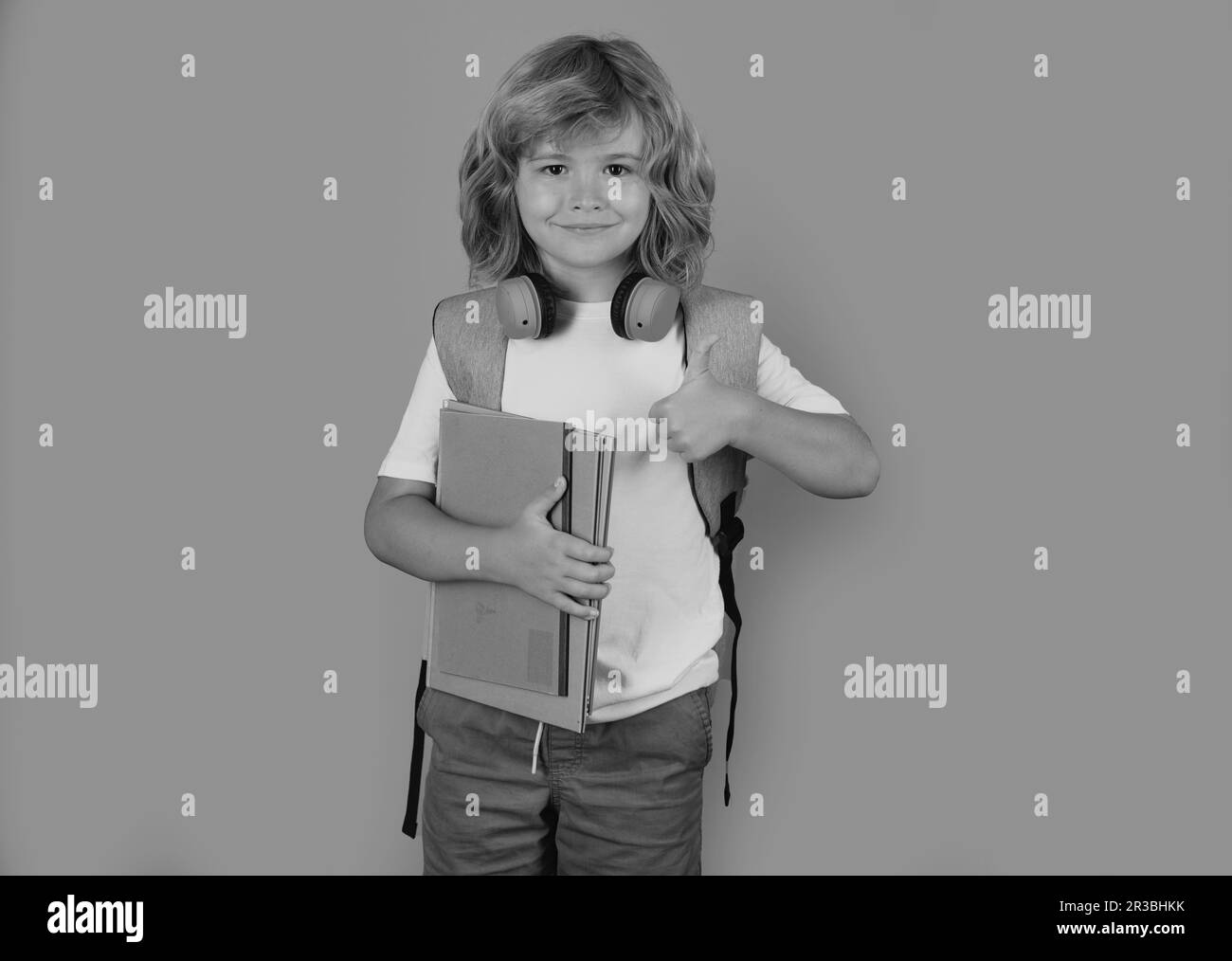 Portrait of pupil student hold book on grey isolated studio background ...