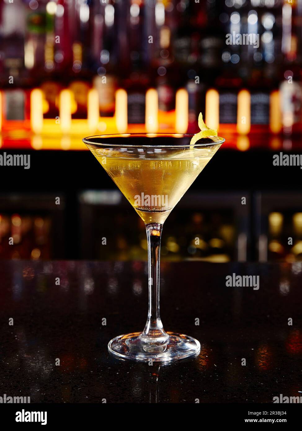 A cocktail with lemon zest in a bar Stock Photo - Alamy