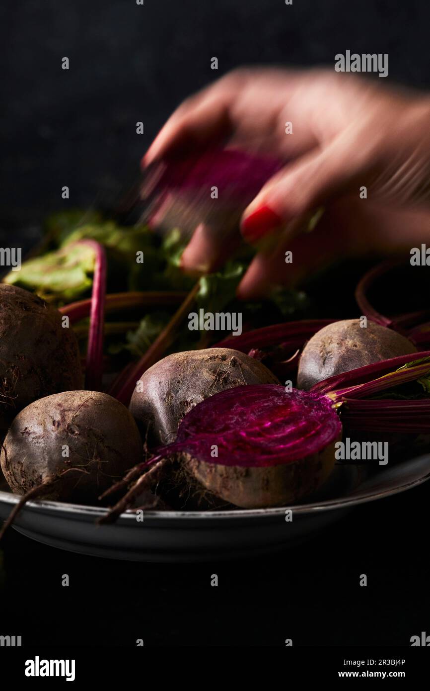 Hand takes fresh beetroot from the plate Stock Photo - Alamy