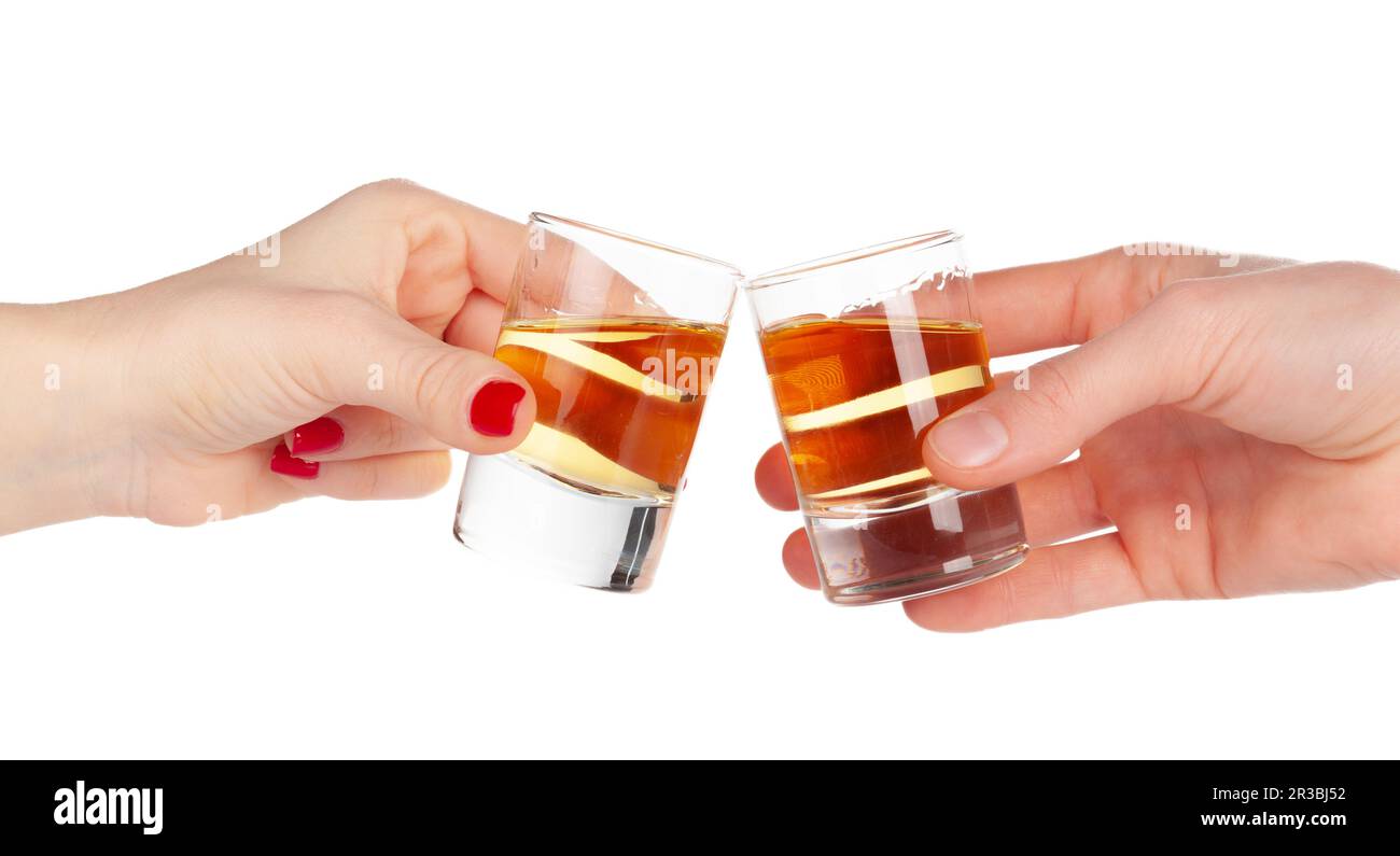Two hands clinking shots of alcoholic beverage together Stock Photo - Alamy