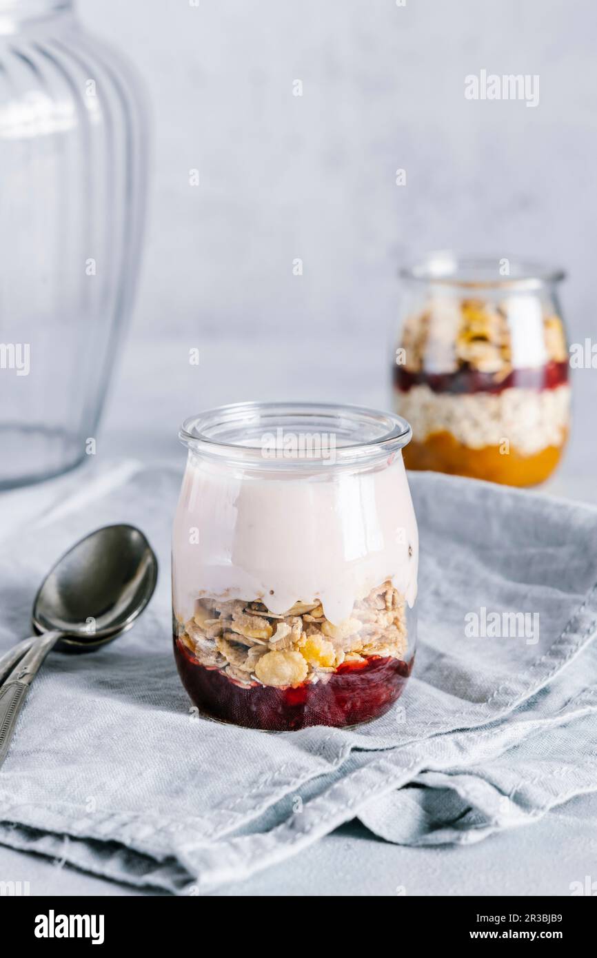 Healthy raspberry parfaits with yogurt in glass jars Stock Photo - Alamy