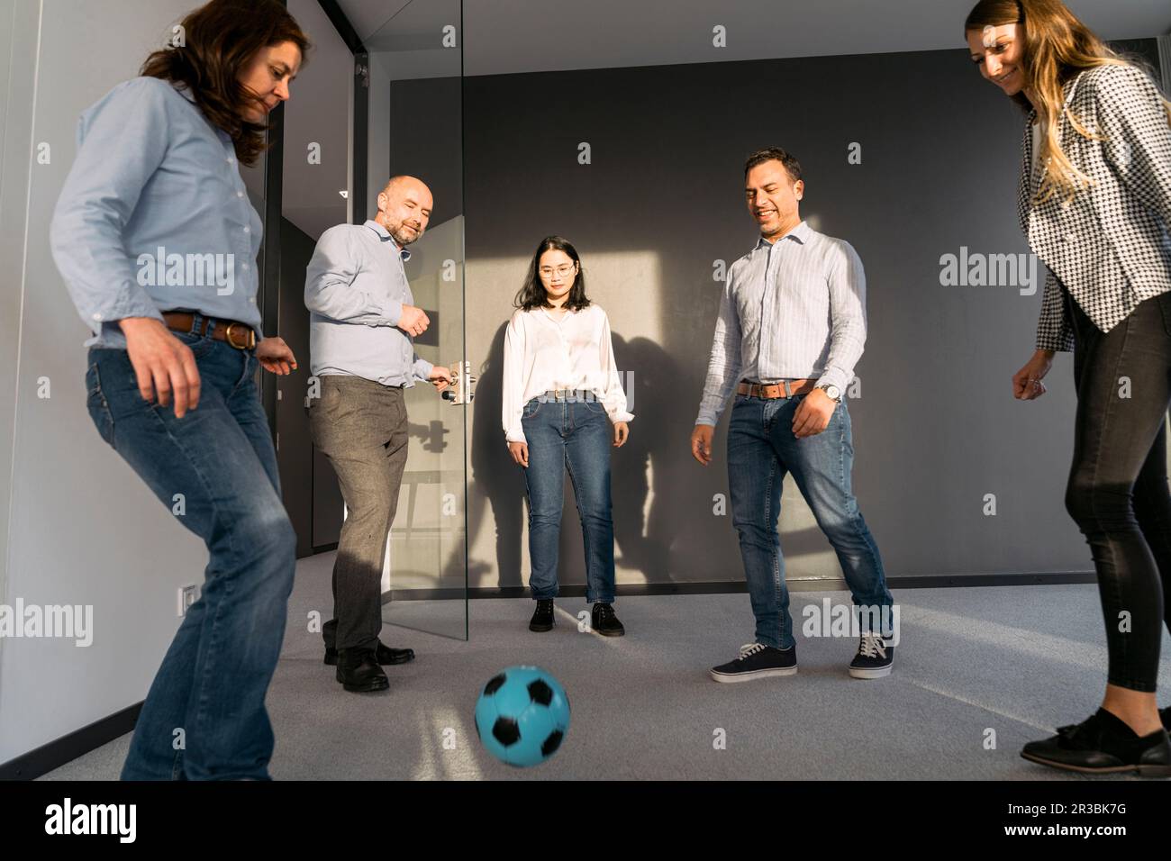 Business colleagues playing soccer in office Stock Photo - Alamy