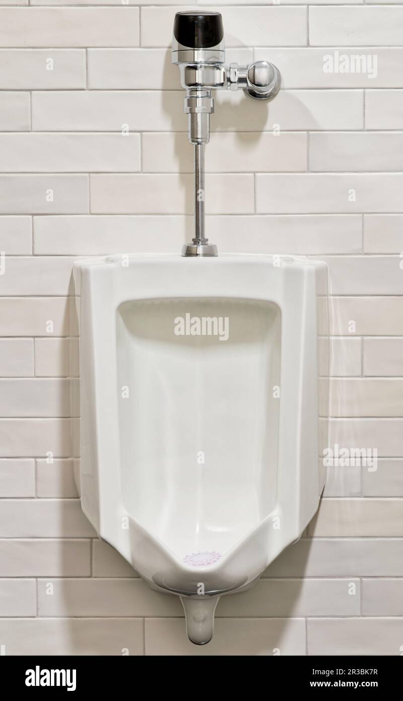 Single sensor operated modern urinal in a men's public restroom with a ...