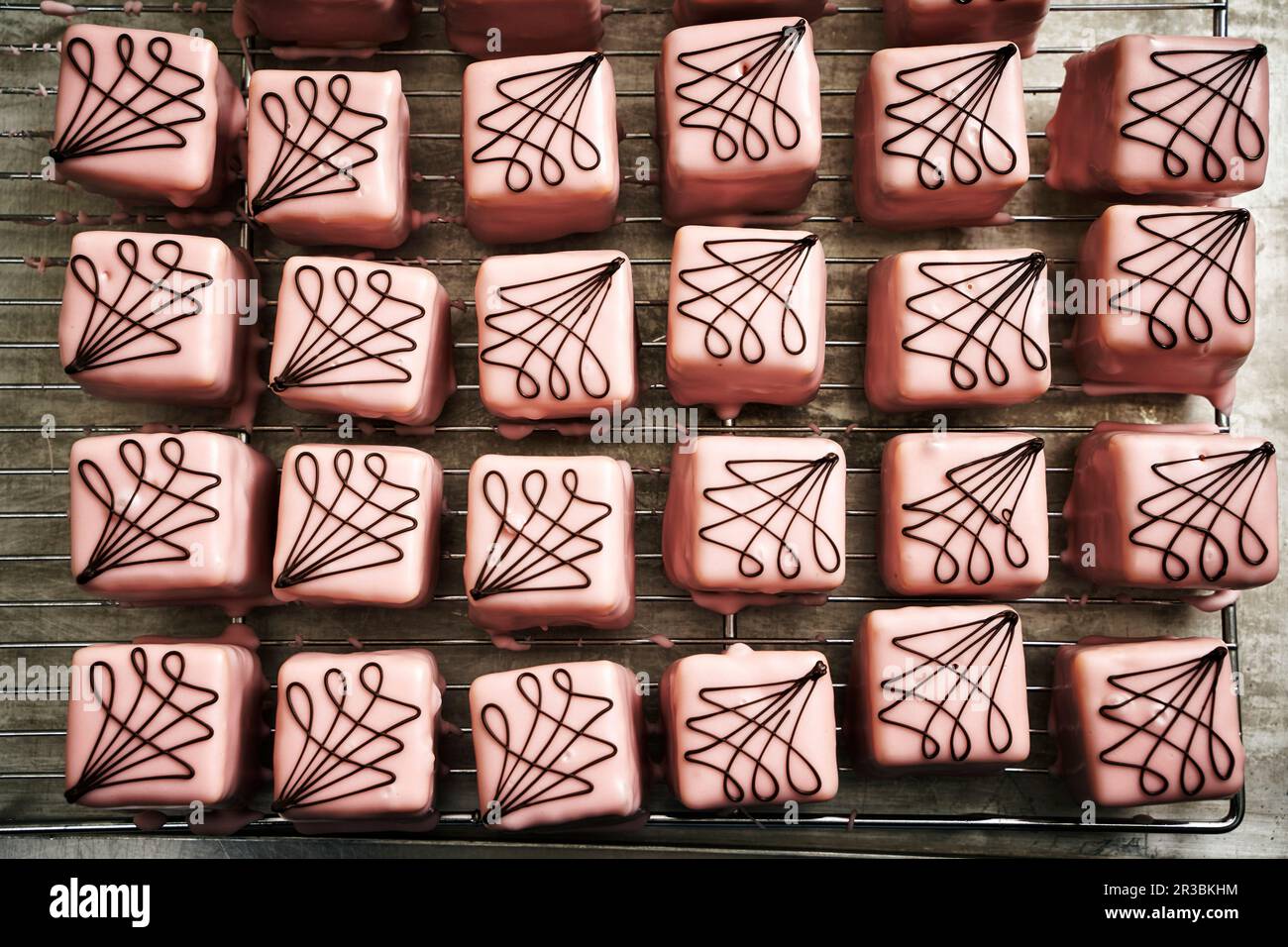 Petit fours with pink icing Stock Photo - Alamy