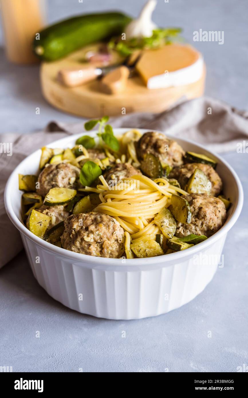Steamed meatballs with zucchini and garlic pasta Stock Photo - Alamy