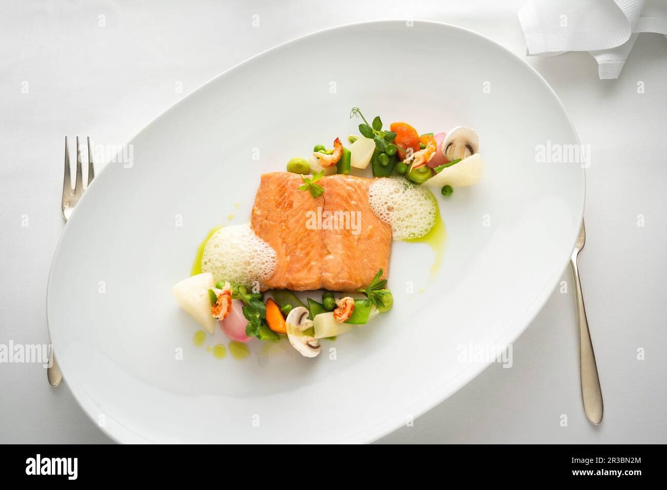 Fried char with sautéed vegetables and a frothy sauce Stock Photo - Alamy