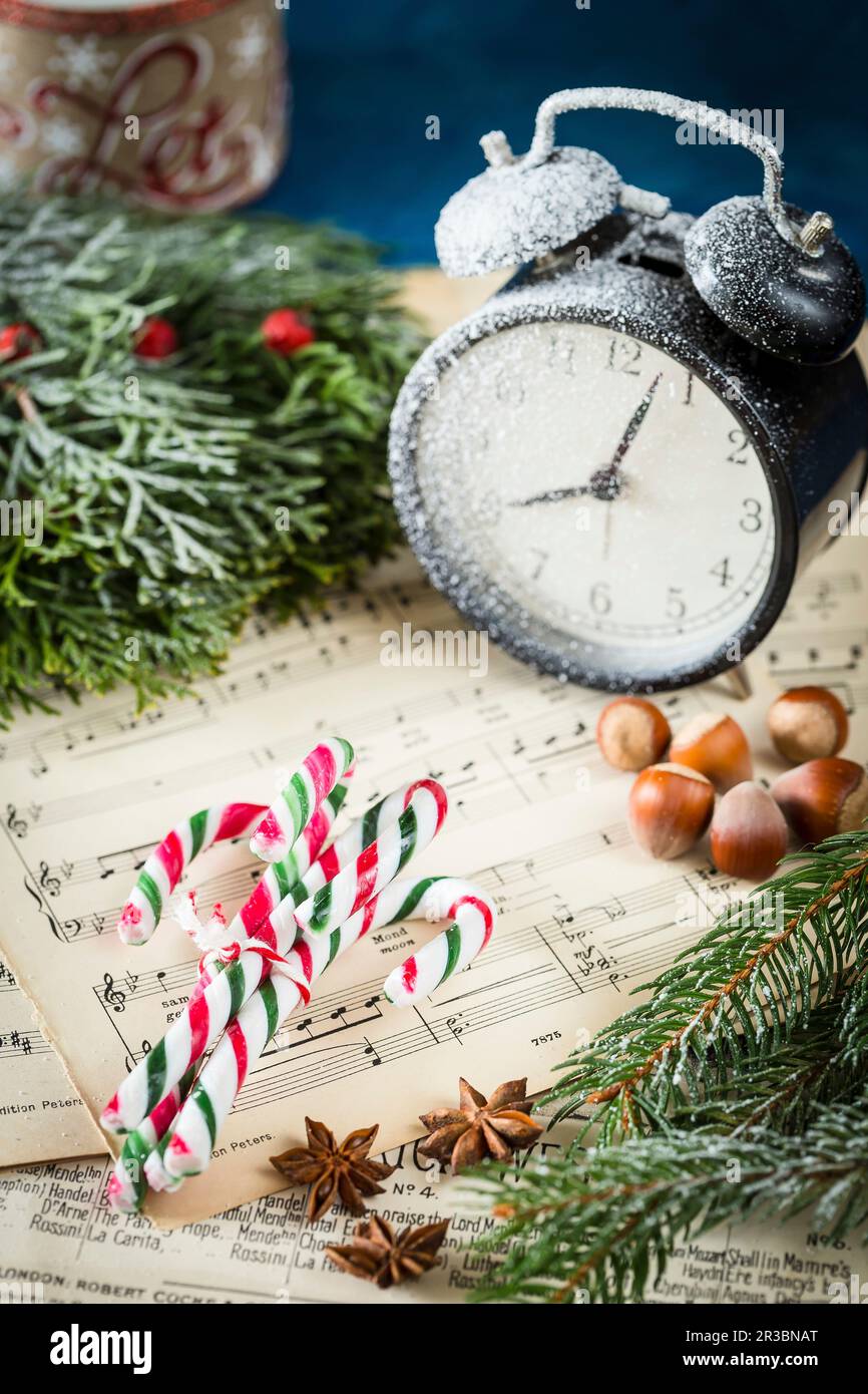 Candy canes, hazelnuts and alarm clock on music sheet Stock Photo - Alamy