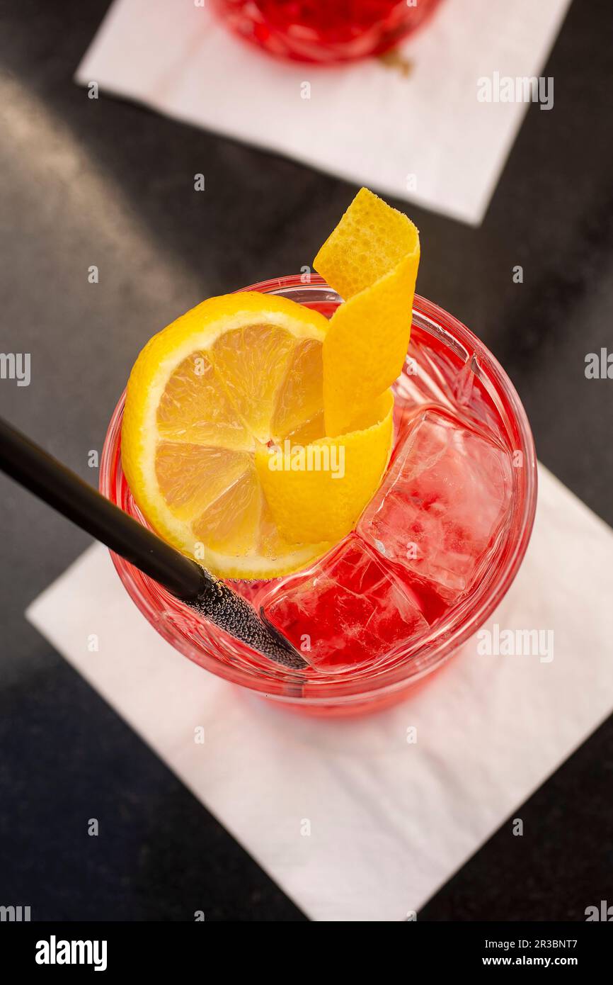 Campari soda with ice cubes and a lemon slice Stock Photo - Alamy