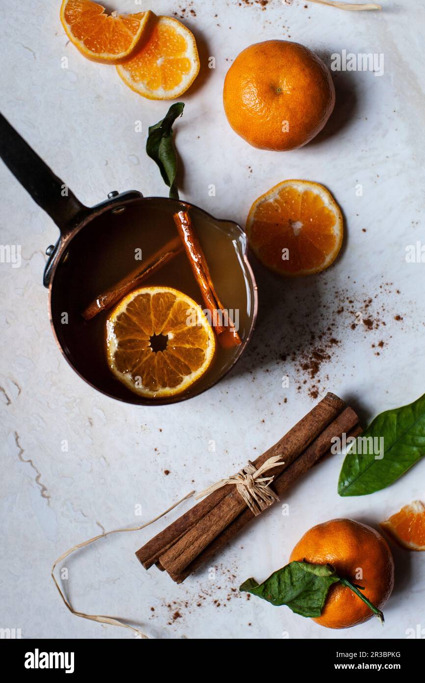 Apple cider heated in a copper pot, with oranges with leaves, orange ...