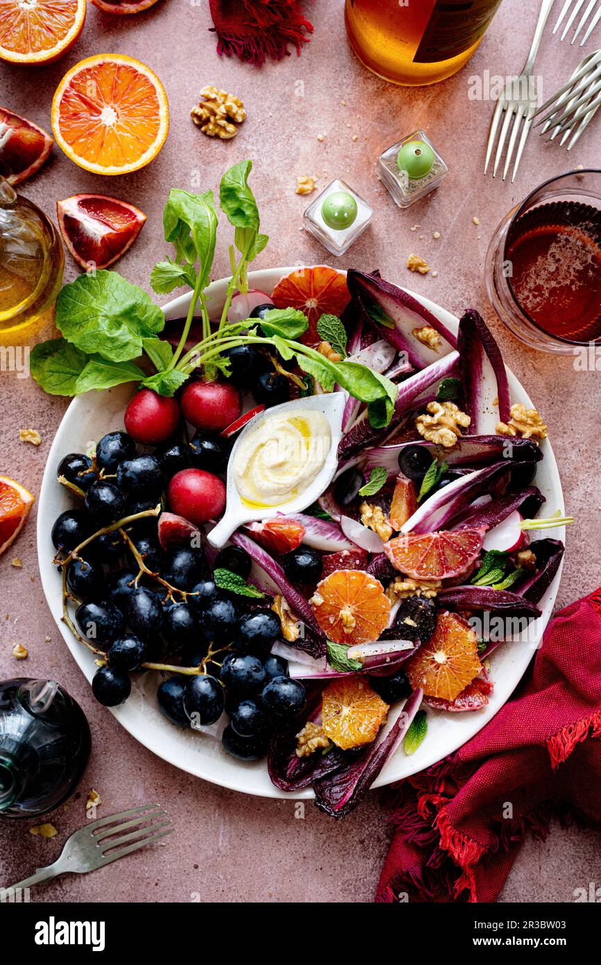 Fruits, red chicory radish and walnuts with hummus Stock Photo - Alamy