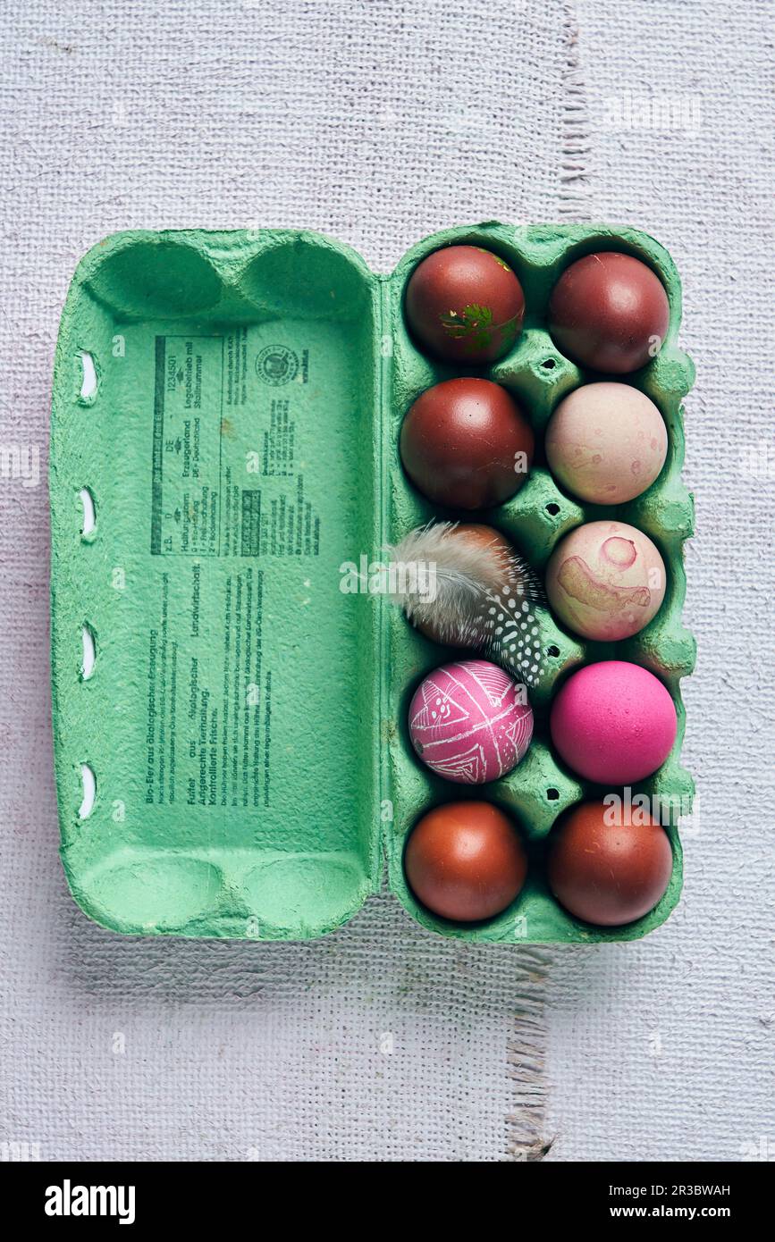 Colorful dyed Easter eggs in red tones in an egg carton Stock Photo - Alamy