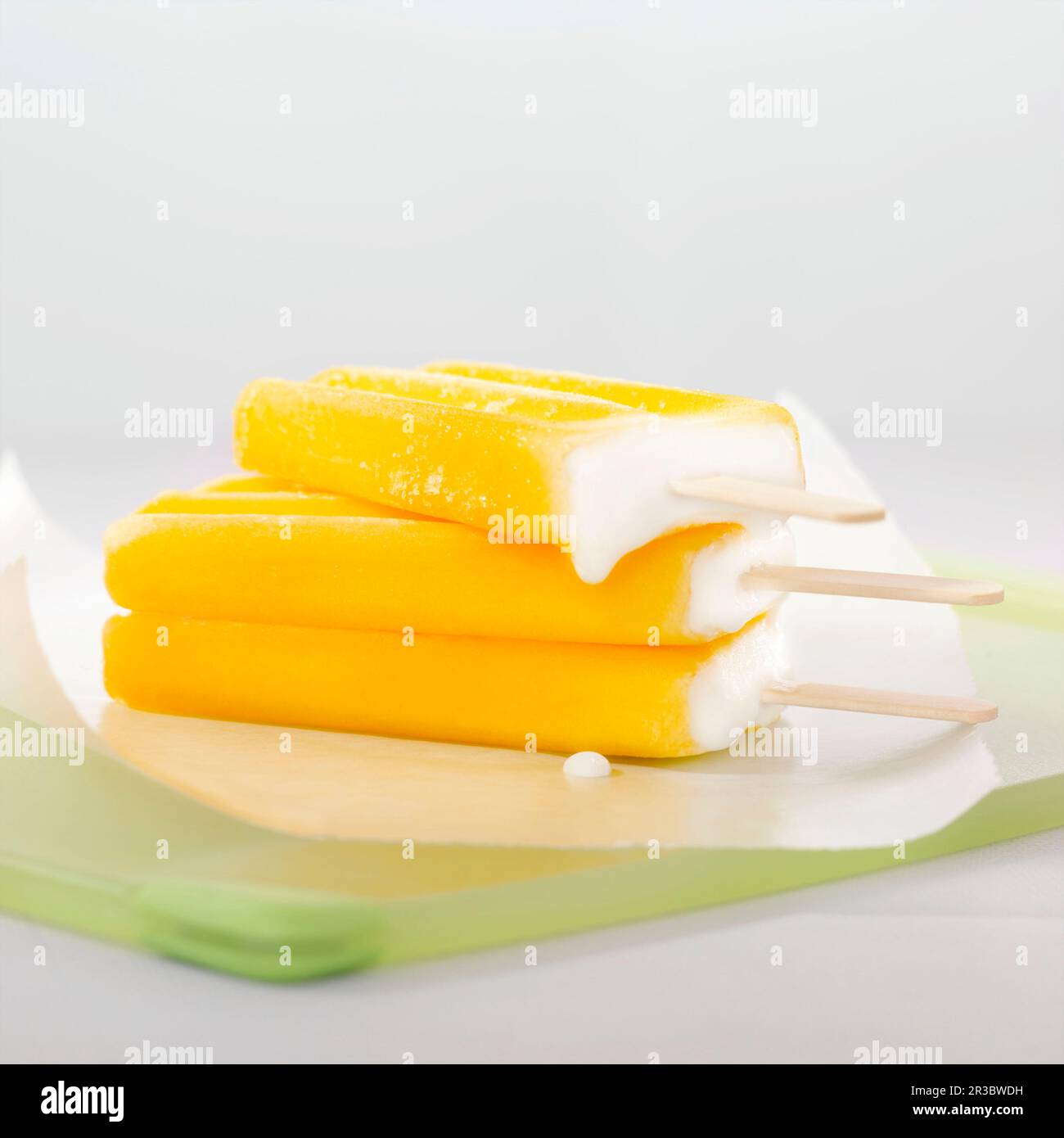 Three orange ice cream popsicles melting Stock Photo - Alamy