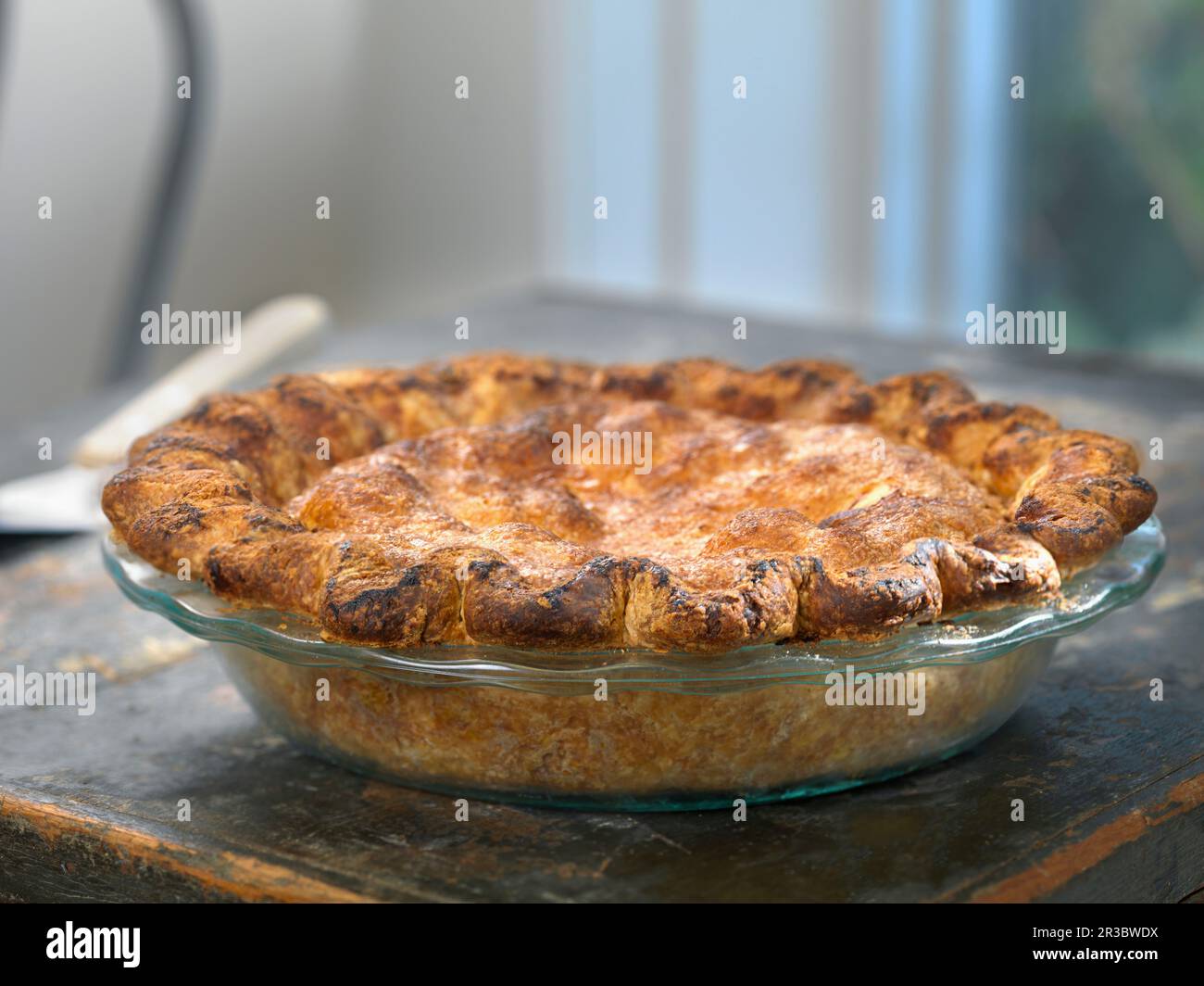 Pie with flakey crust cooling on a wooden table Stock Photo - Alamy