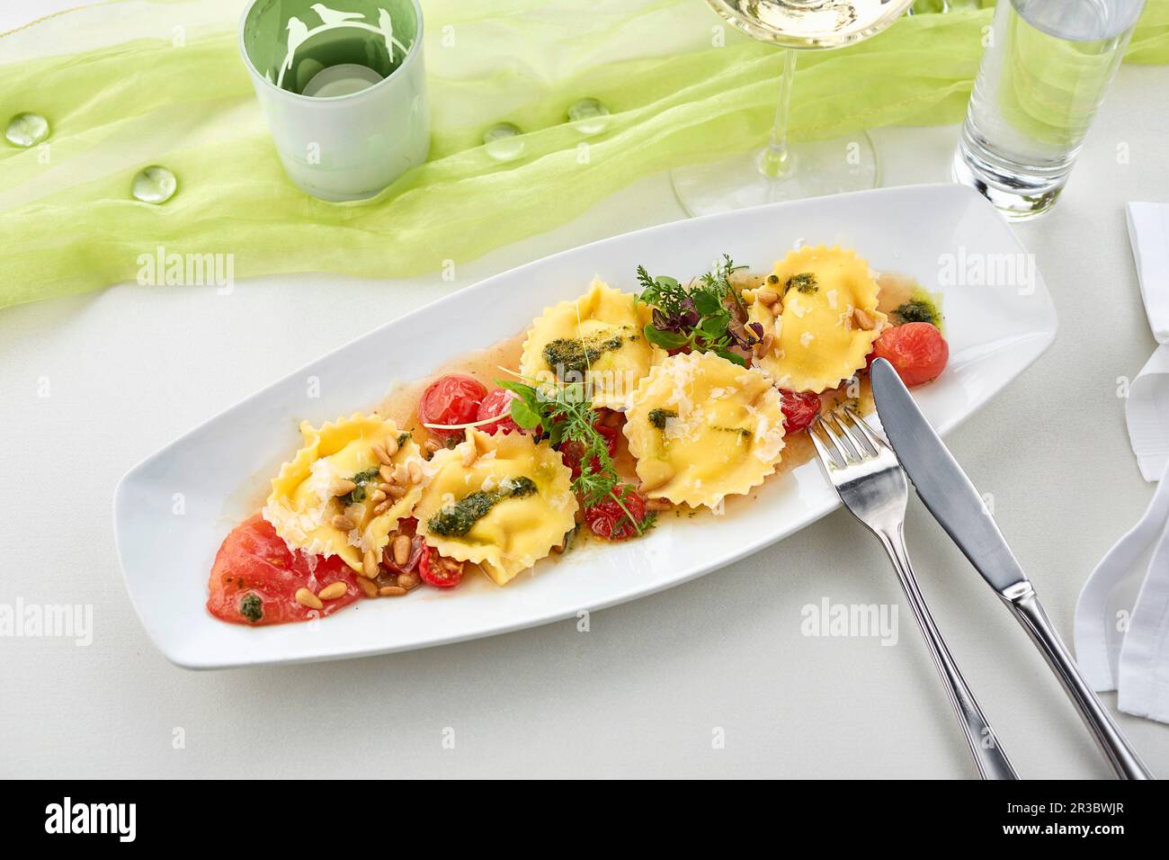 Ravioli with melted tomatoes, herbs and pine nuts Stock Photo - Alamy
