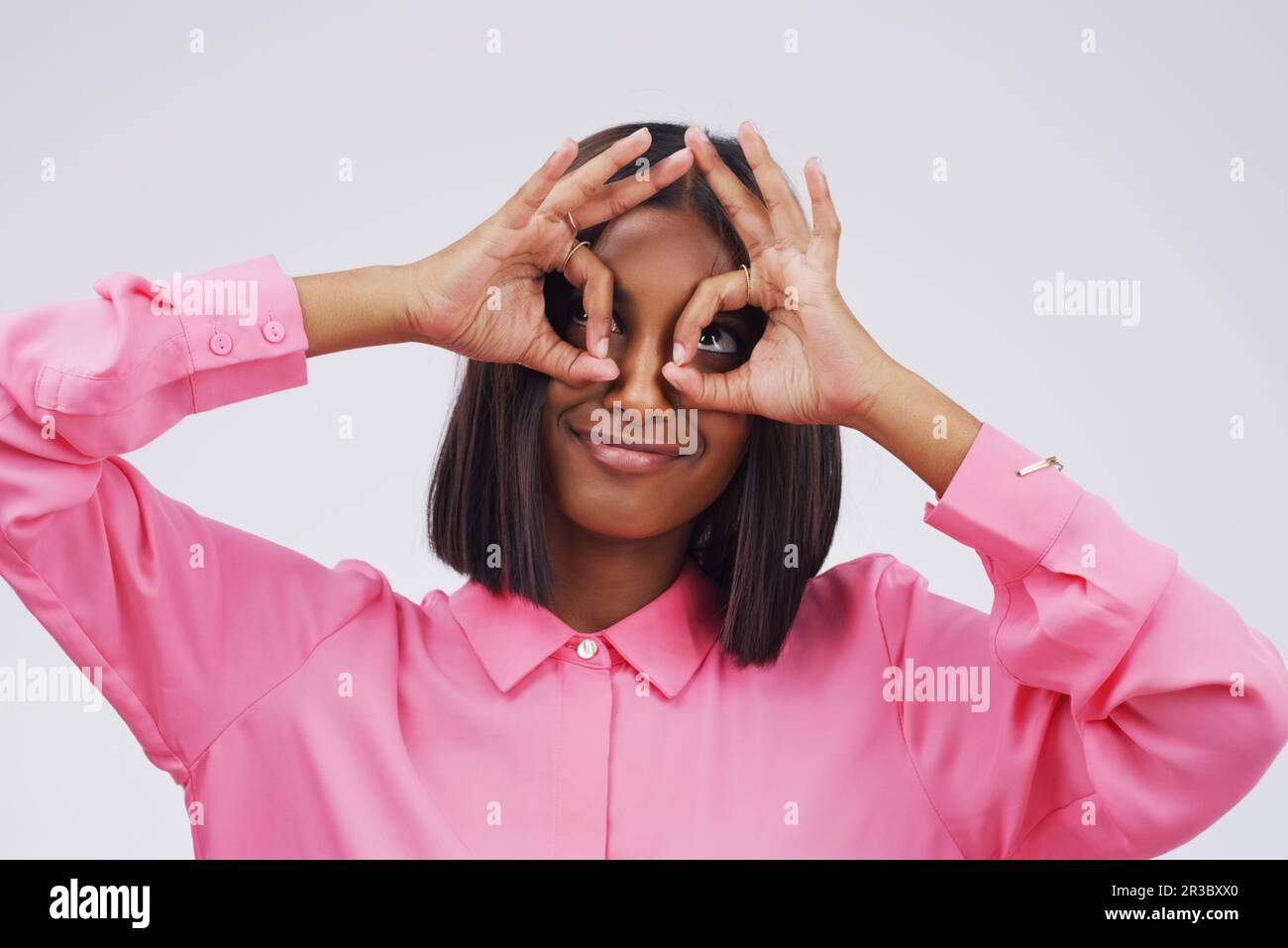 Quirky, funny face and finger glasses with an indian woman in studio on ...