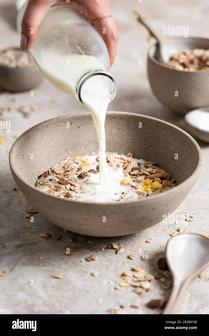 Hand pouring milk bowl cereal hi-res stock photography and images - Alamy