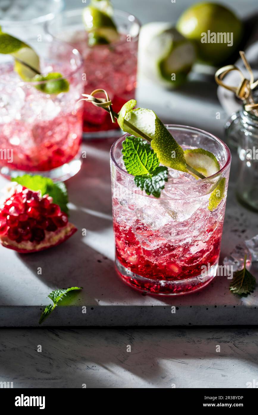 Pomegranate and raspberry gin fizz with mint and lime Stock Photo - Alamy