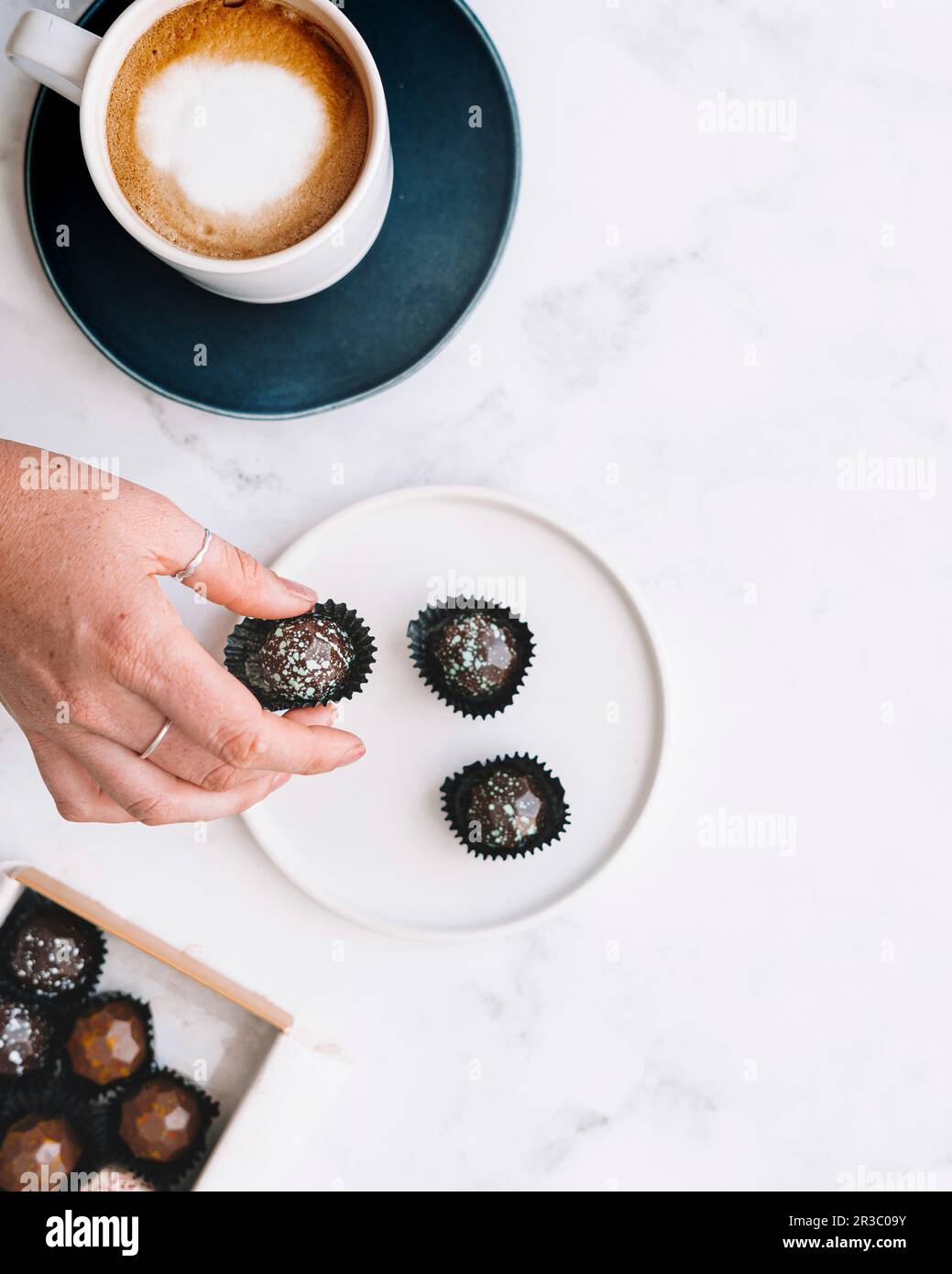 Chocolate bon bons with hand Stock Photo - Alamy