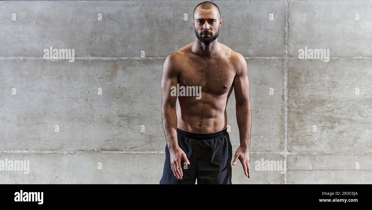 A muscular man poses in the gym, showcasing his strength and dedication ...
