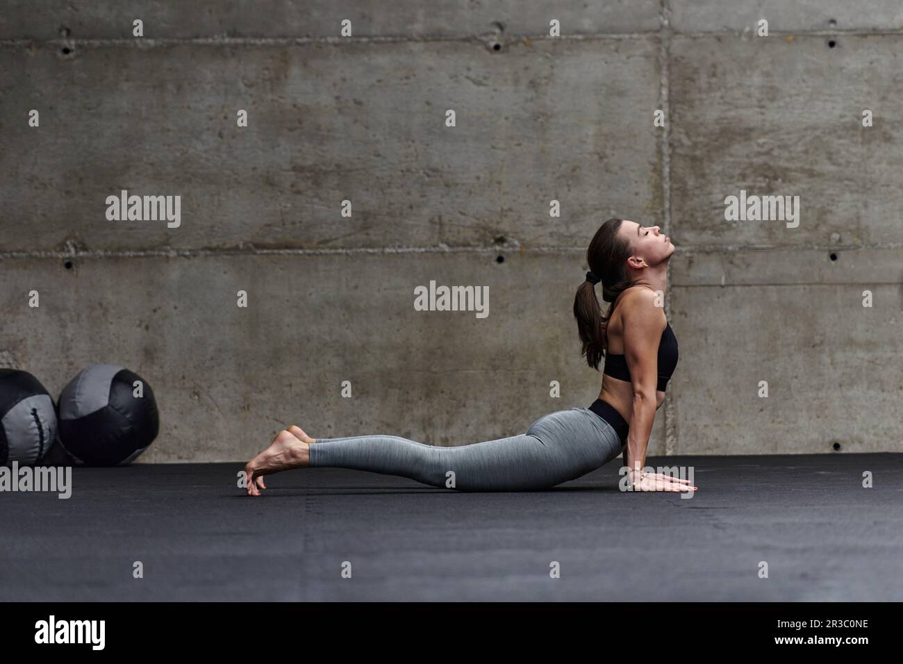 Fit woman in a modern gym working flexibility and strength through ...