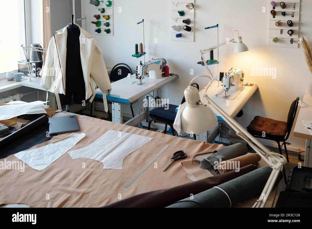 Large table of tailor or leatherworker with paper patterns on textile ...