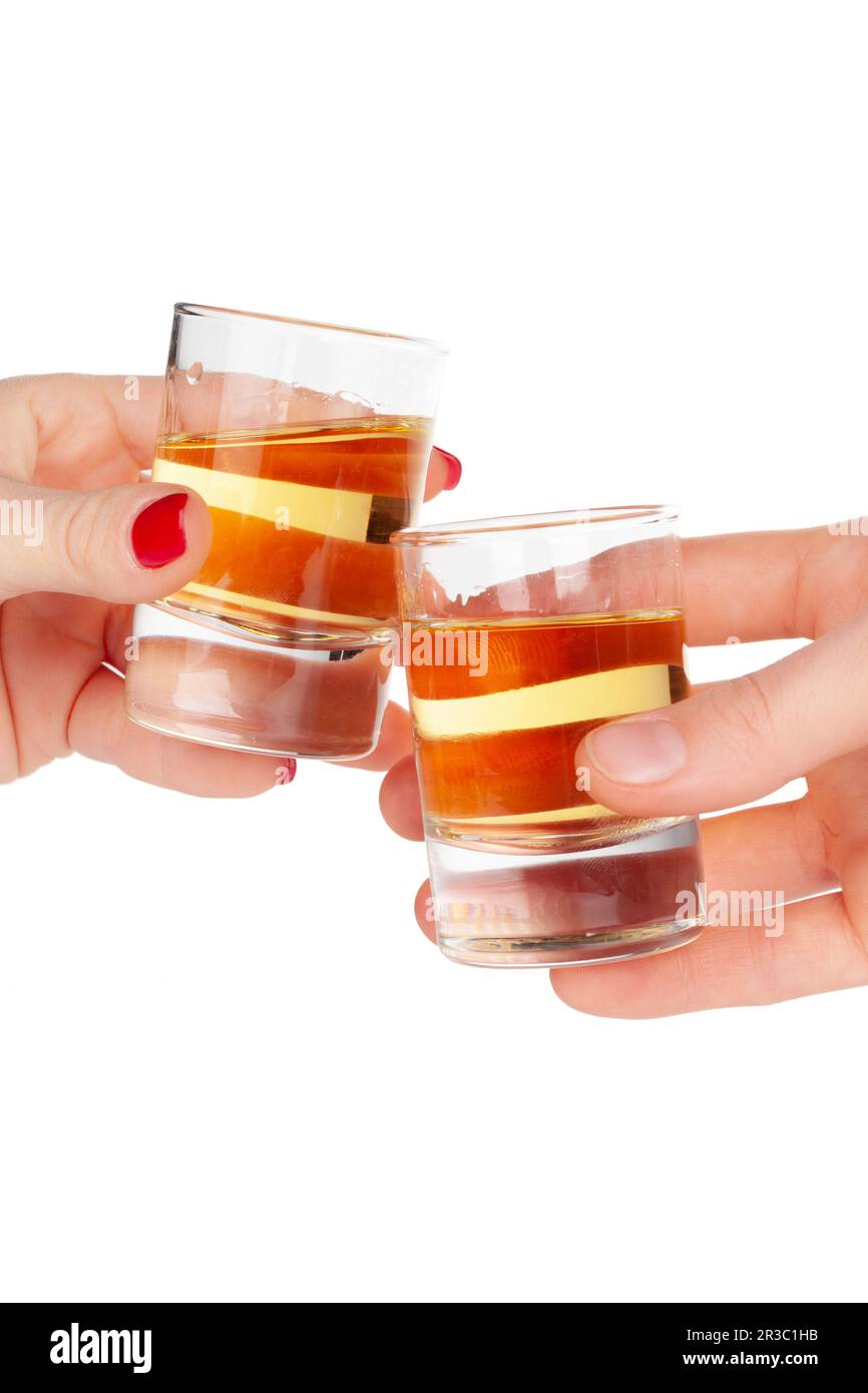Two hands clinking shots of alcoholic beverage together Stock Photo - Alamy