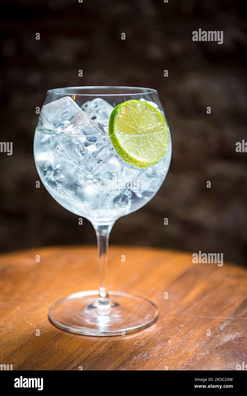 Classic gin and tonic with lime wheel Stock Photo - Alamy