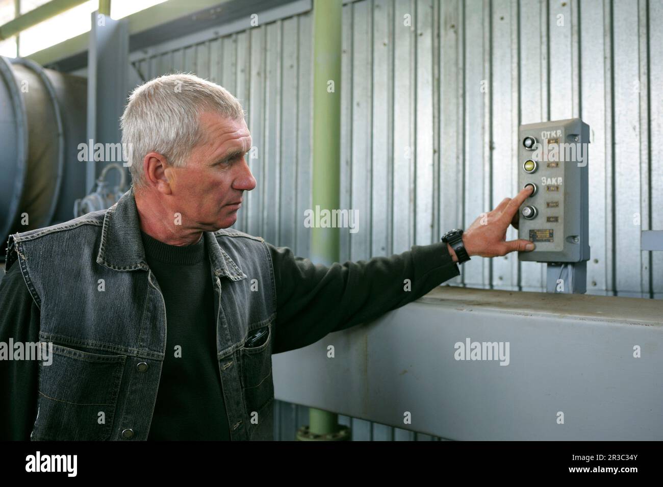 Worker pushing button on a control panel of pumping station Stock Photo ...
