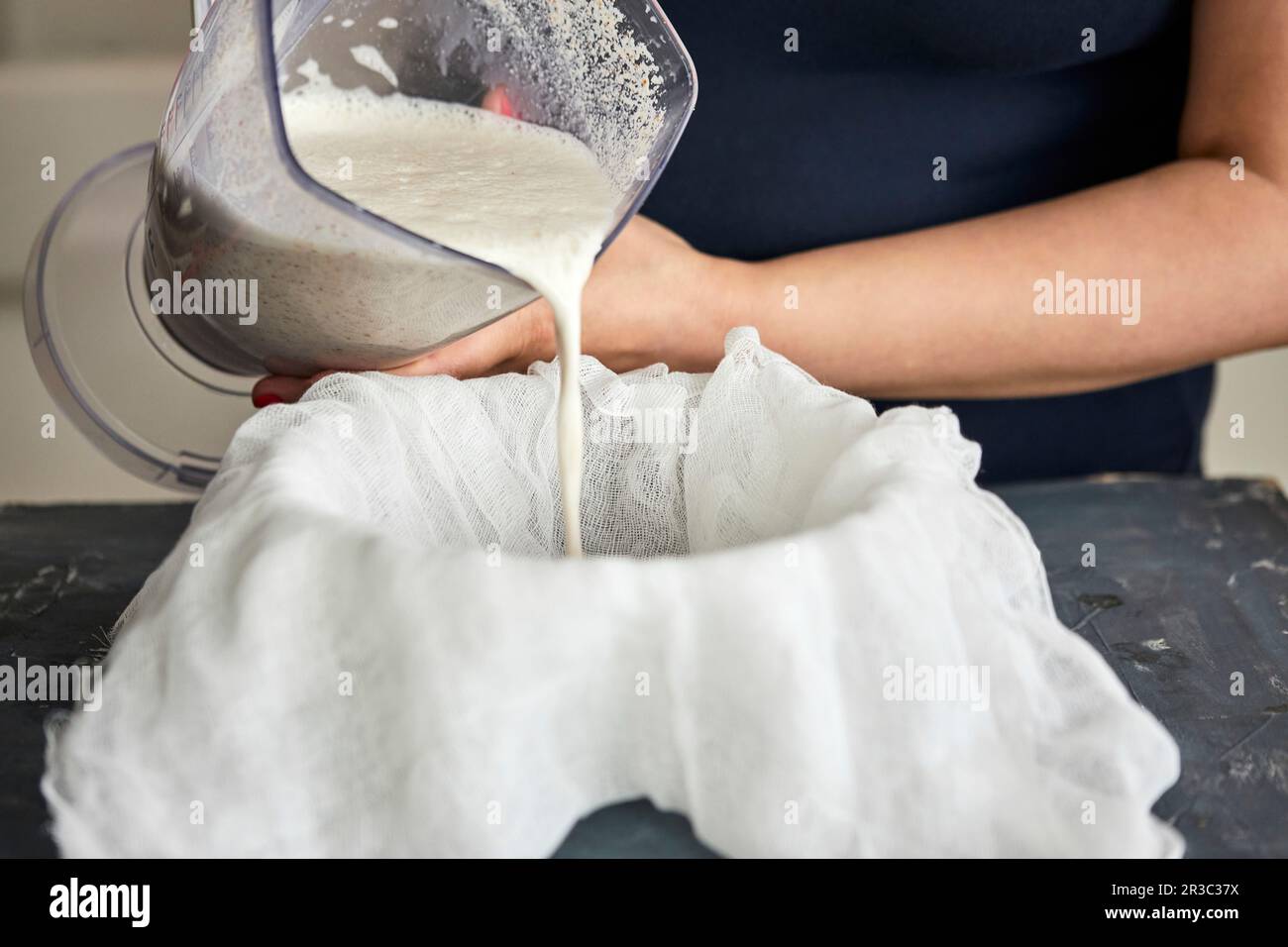 Making almond milk: strain the mixture of ground almonds and water ...