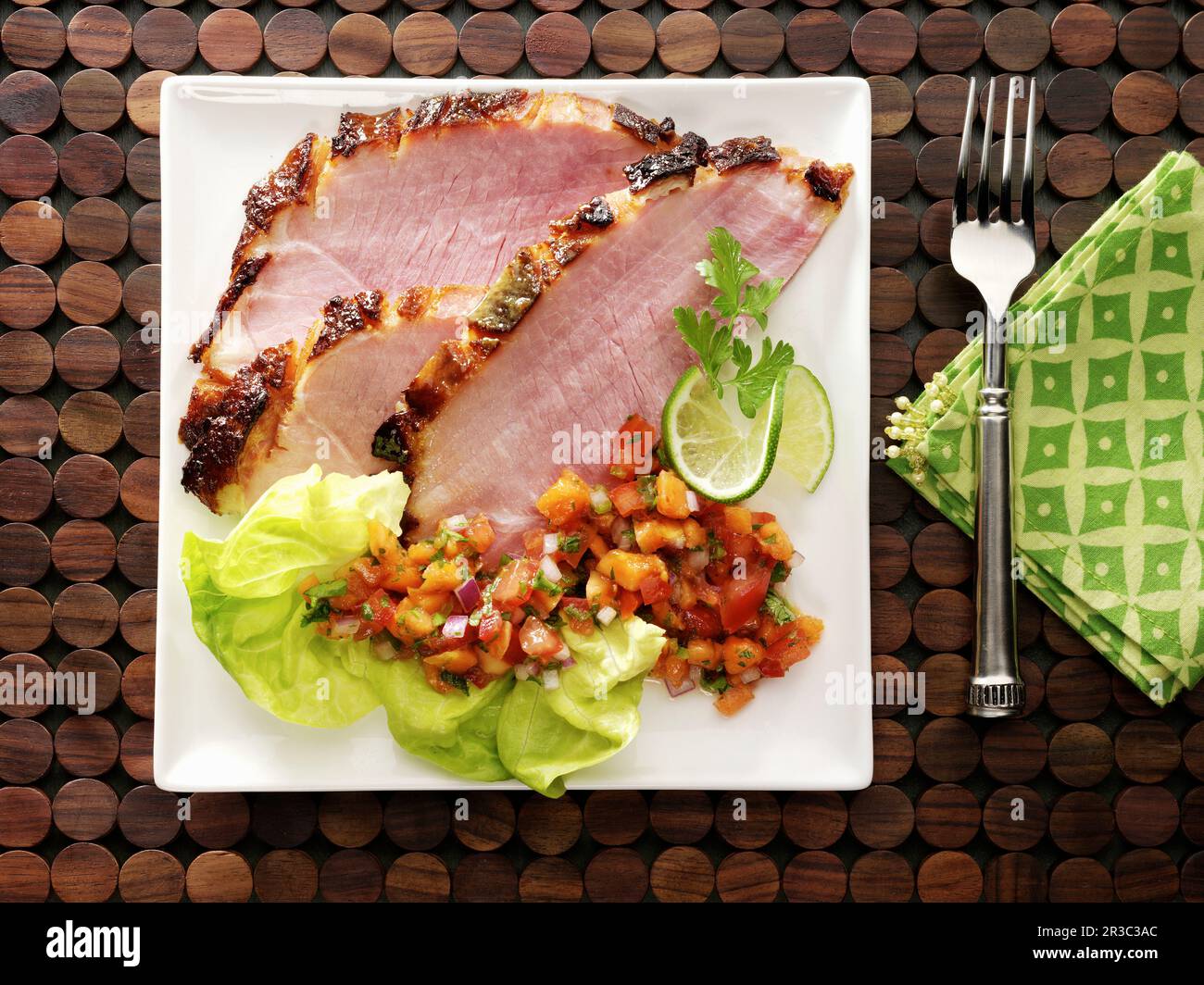 Honey mustard glazed baked ham slices with a chopped tomato salad Stock ...