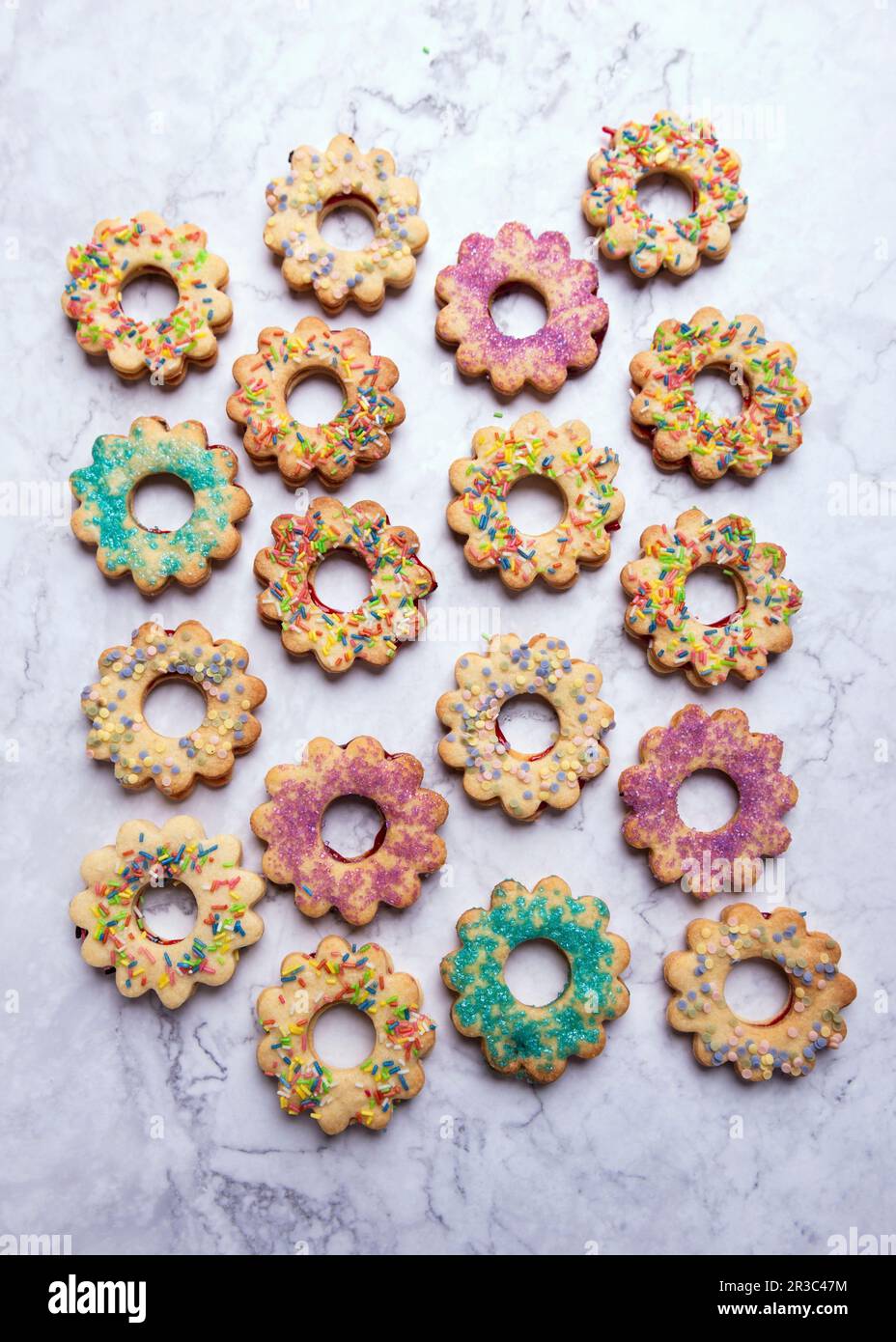 Vegan shortcrust biscuits with a jam filling and colourful sugar ...