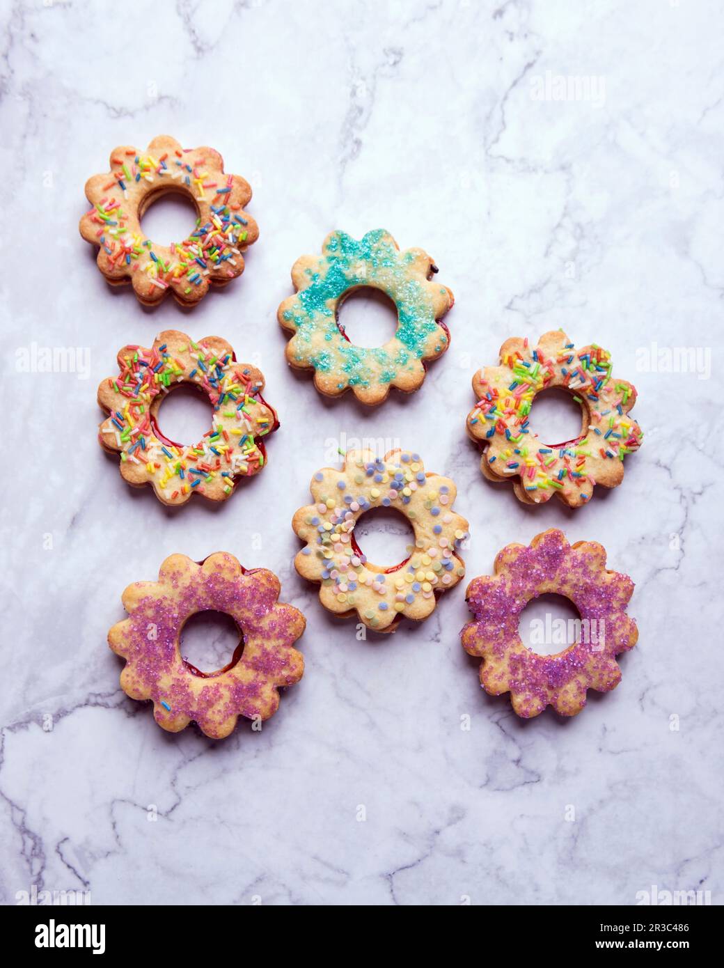 Vegan shortcrust biscuits with a jam filling and colourful sugar ...